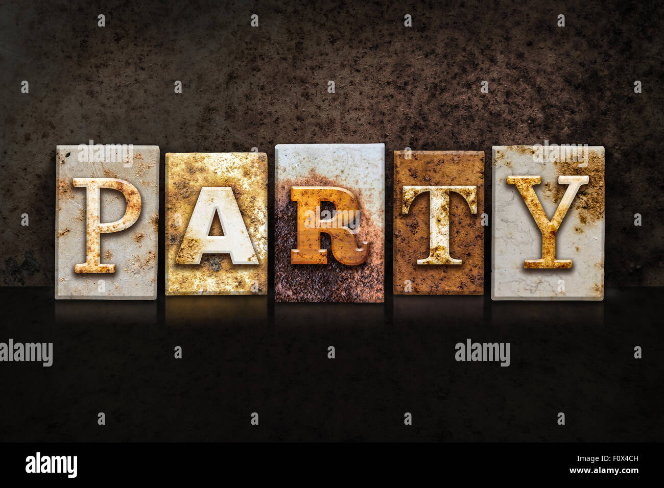 The word "PARTY" written in rusty metal letterpress type on a dark ...