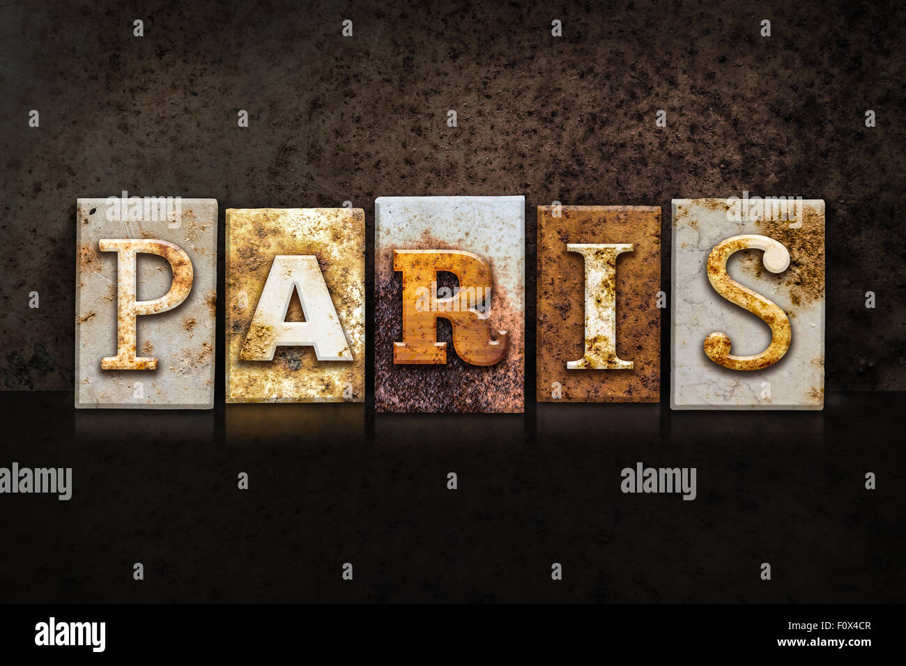 The word "PARIS" written in rusty metal letterpress type on a dark ...