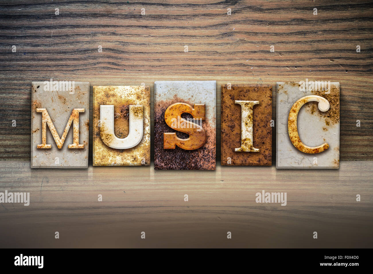 The word "MUSIC" written in rusty metal letterpress type sitting on a ...
