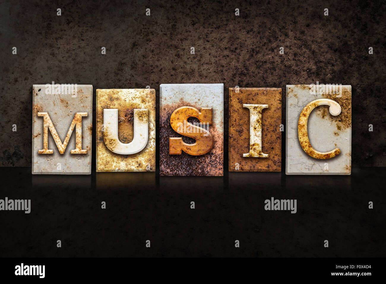 The word "MUSIC" written in rusty metal letterpress type on a dark ...