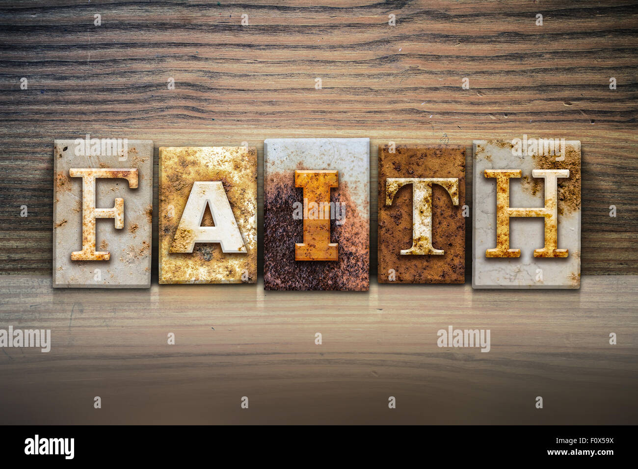 The word "FAITH" written in rusty metal letterpress type sitting on a ...