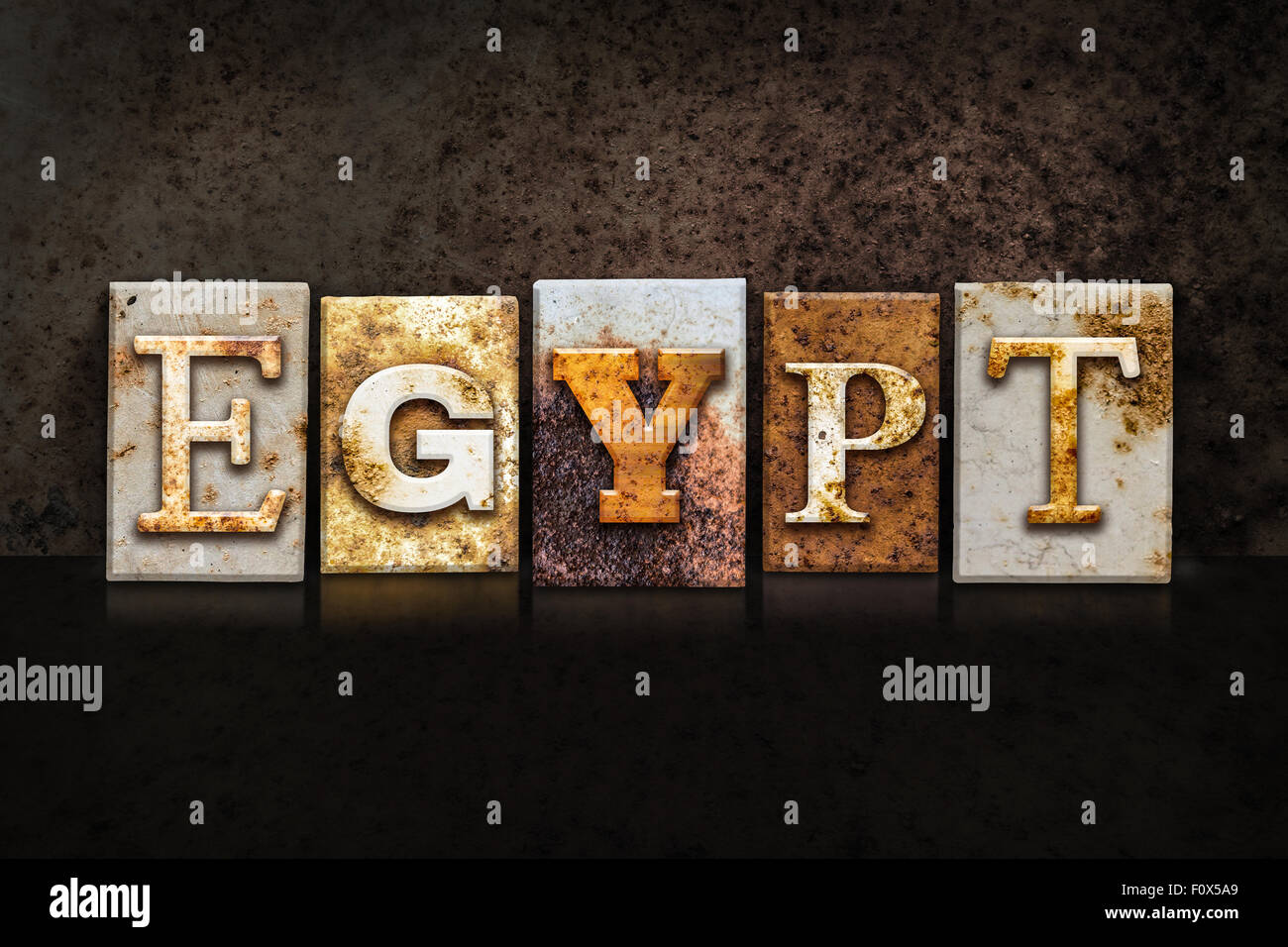 The word "EGYPT" written in rusty metal letterpress type on a dark ...