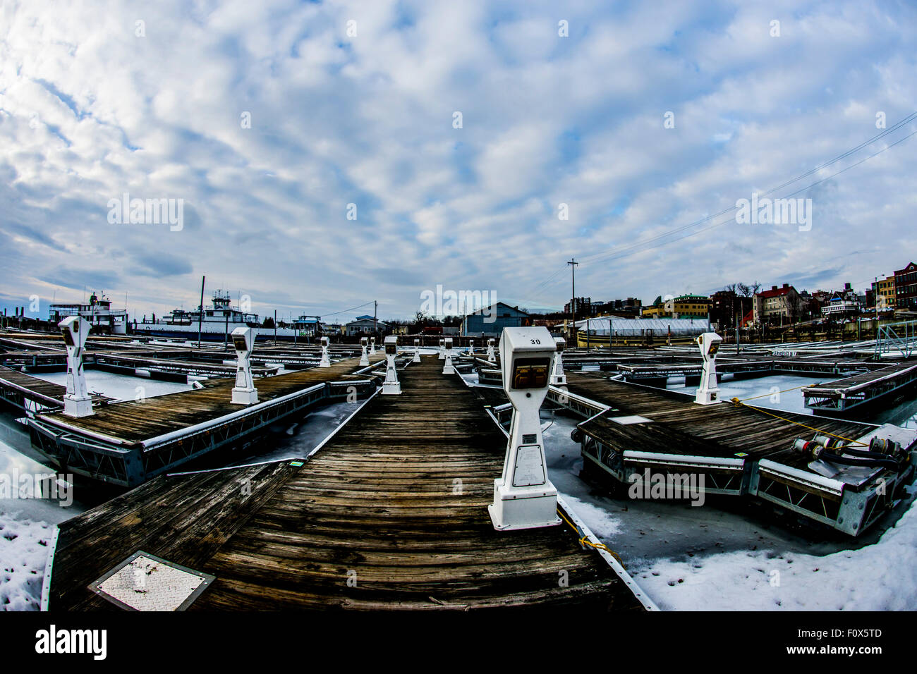 A pier in Burlington, poles jut out of the frozen lake Stock Photo - Alamy
