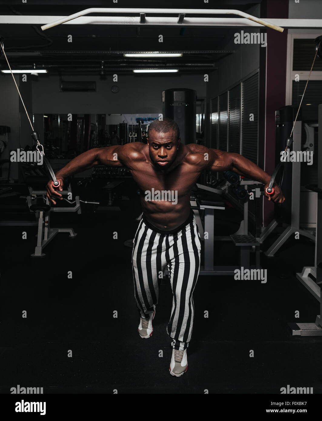 Weight training African doing bodybuilding in gym Stock Photo - Alamy