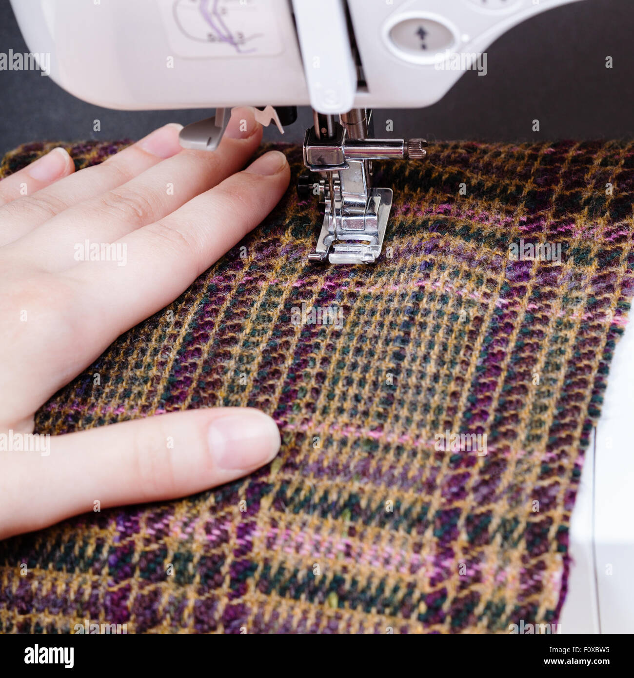 sewer hand and foot of sewing machine on woolen cloth close up Stock ...