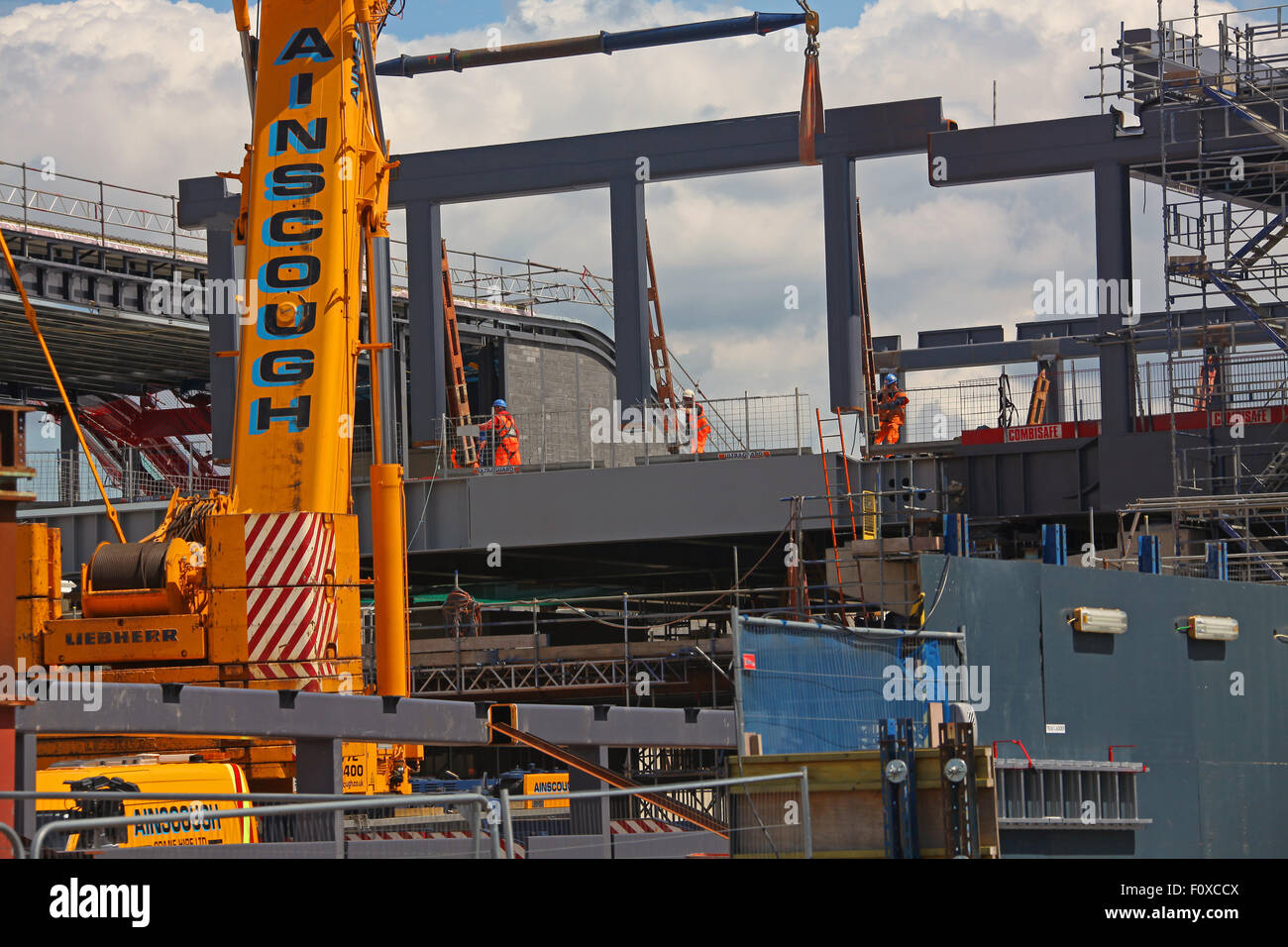 A large Crane lifting a large steel building section up to a platform ...