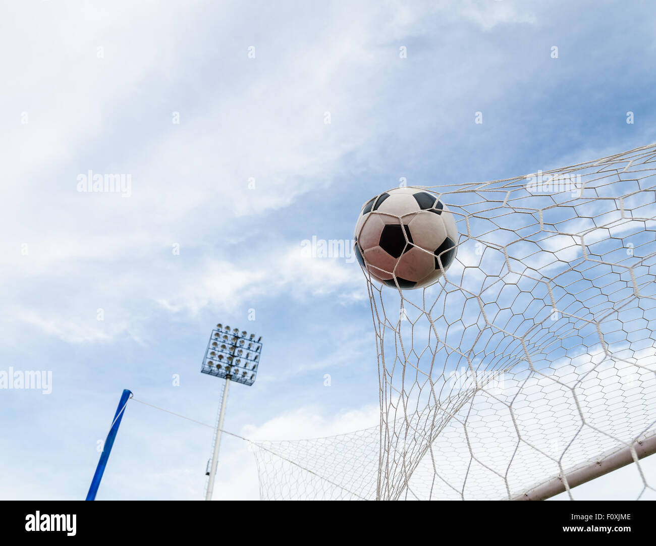 Soccer football in Goal net with the sky field Stock Photo - Alamy