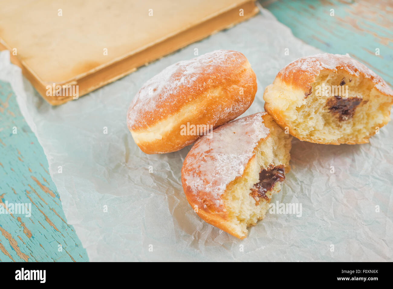 Sweet sugary donuts filled with chocolate cream on rustic wooden ...
