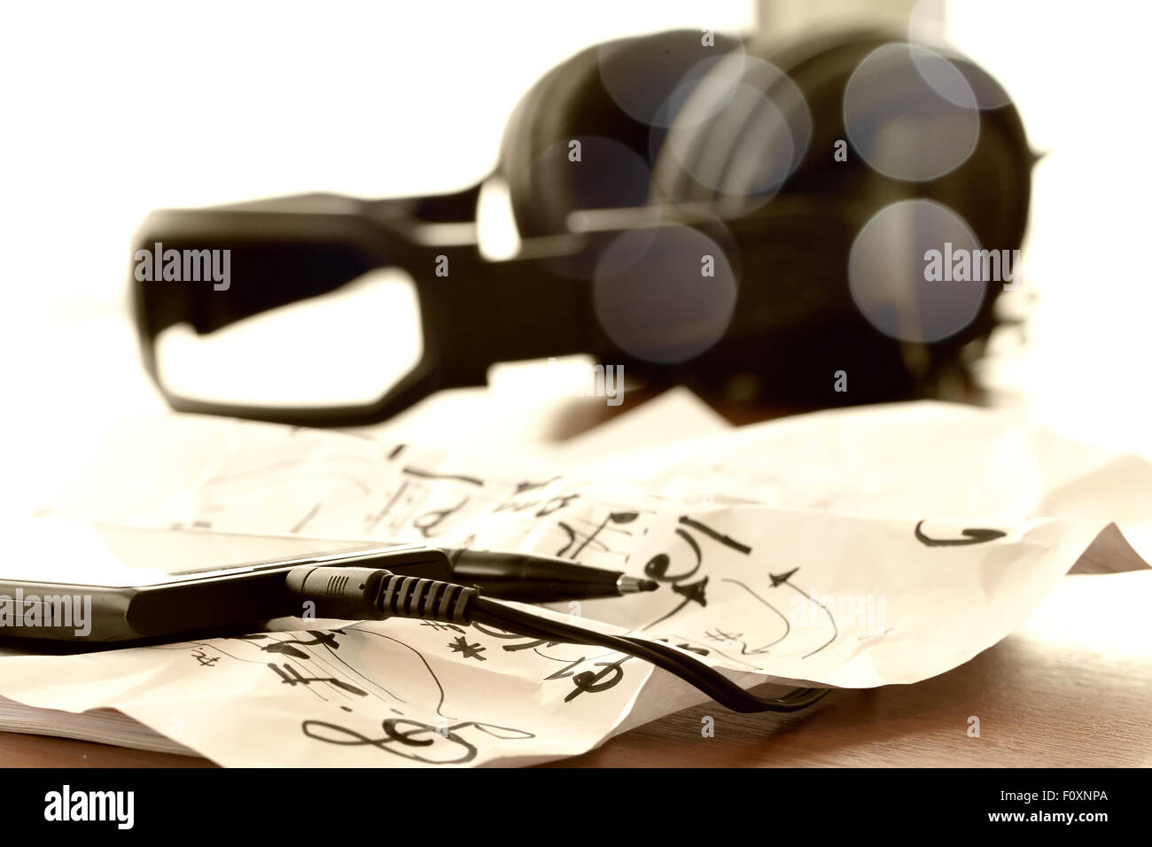 Closeup of smart phone with jack of headphone on musical notes paper ...
