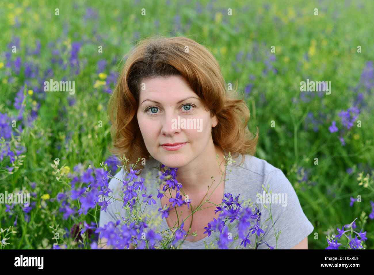 Adult woman in a meadow with wild flowers Stock Photo - Alamy