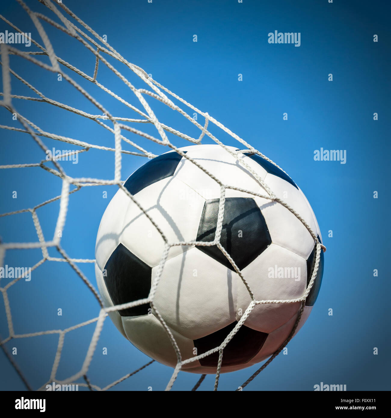 Soccer football in Goal net with the sky field Stock Photo - Alamy
