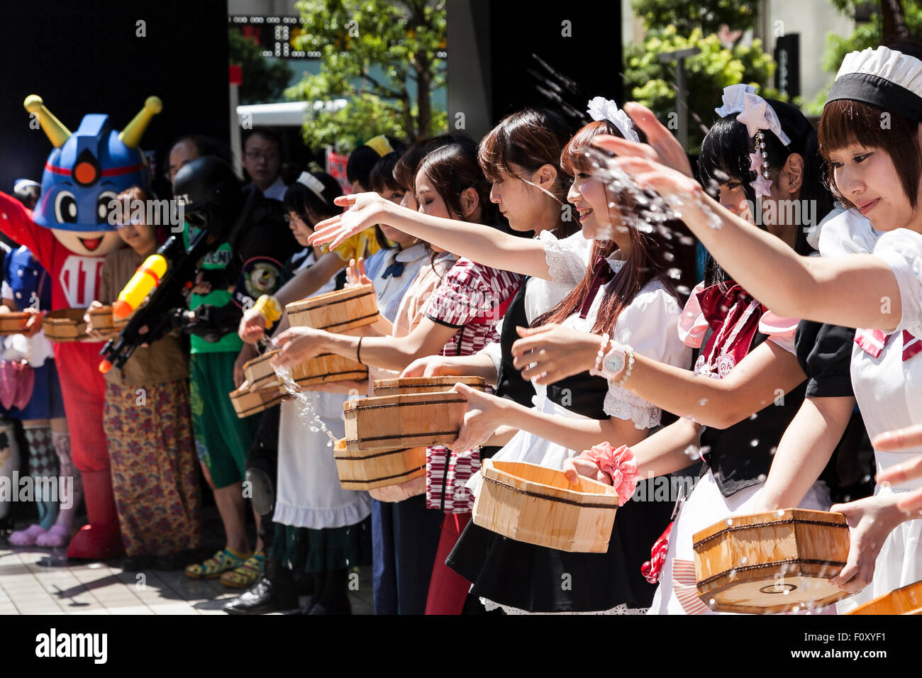 Maid cafe waitresses and cosplayers sprinkle water during the ...