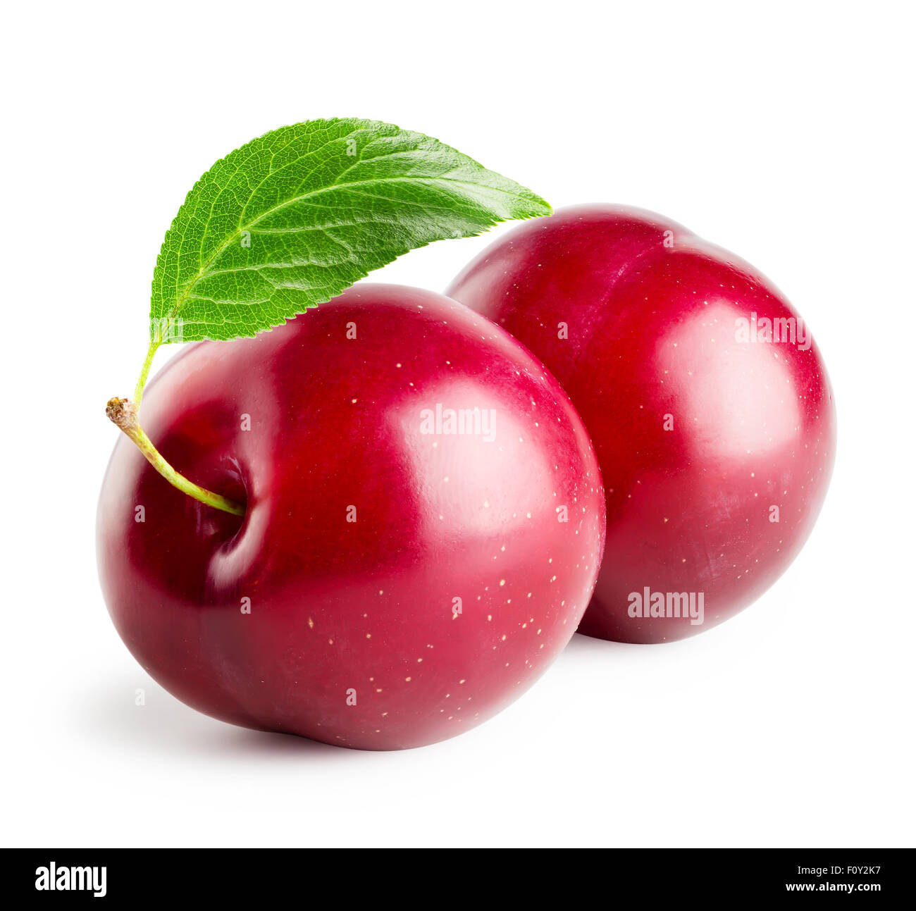 Two plums with leaf isolated on white background Stock Photo - Alamy
