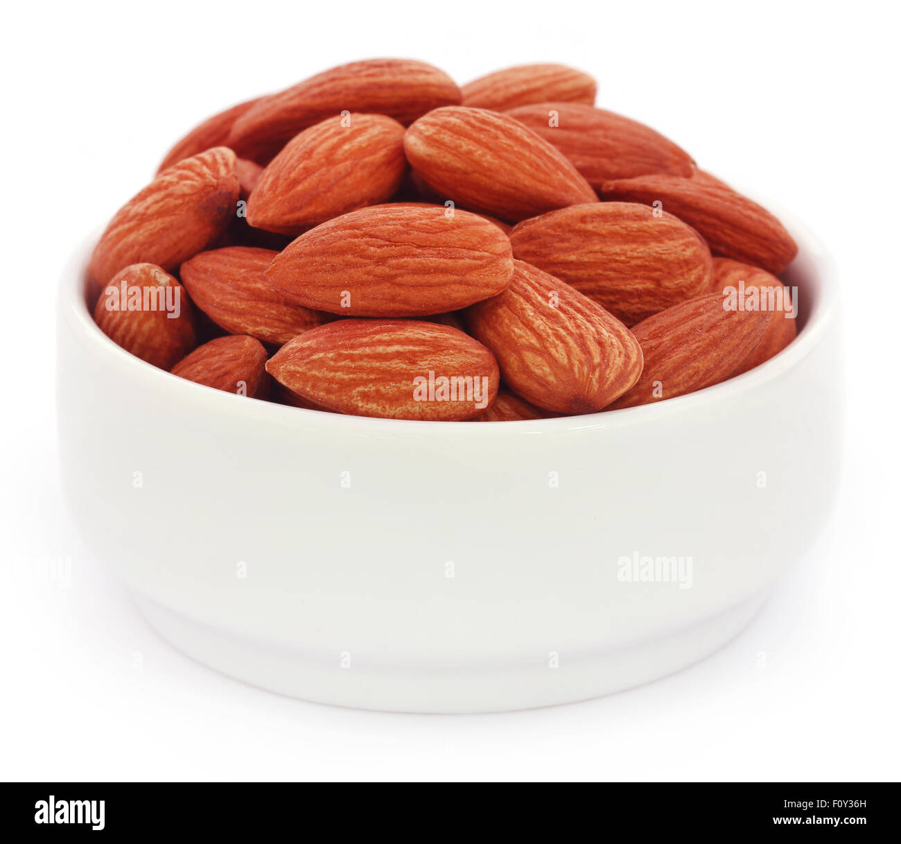 Fresh almonds in a white bowl over white background Stock Photo - Alamy