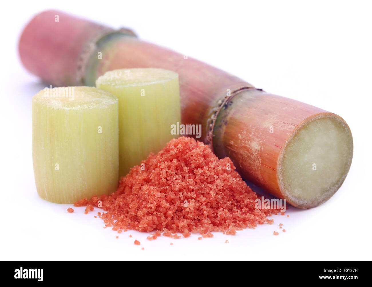 Piece of sugarcane with red sugar over white background Stock Photo - Alamy