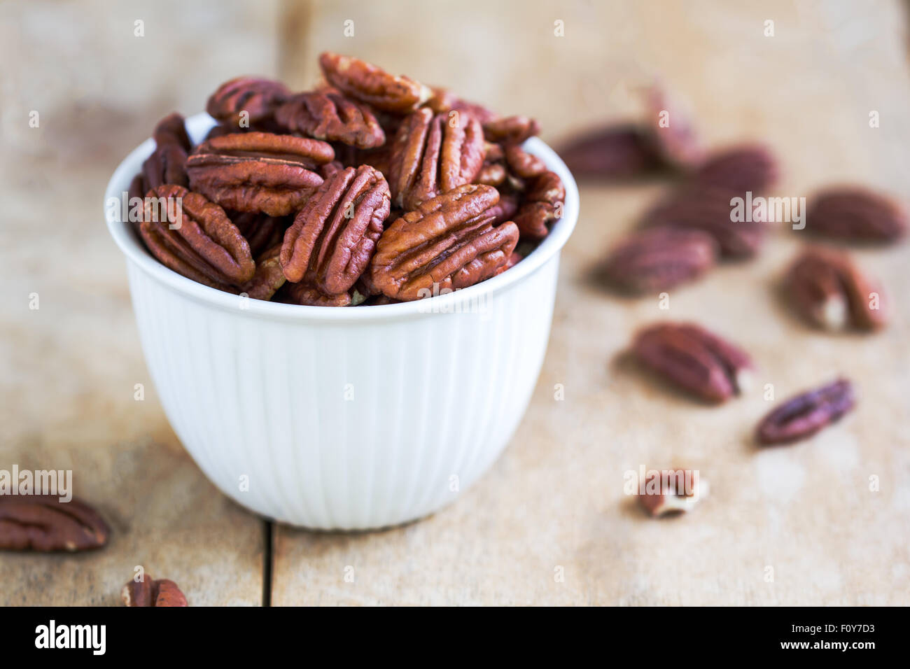 Raw Pecan in a white bowl on wooden board Stock Photo - Alamy