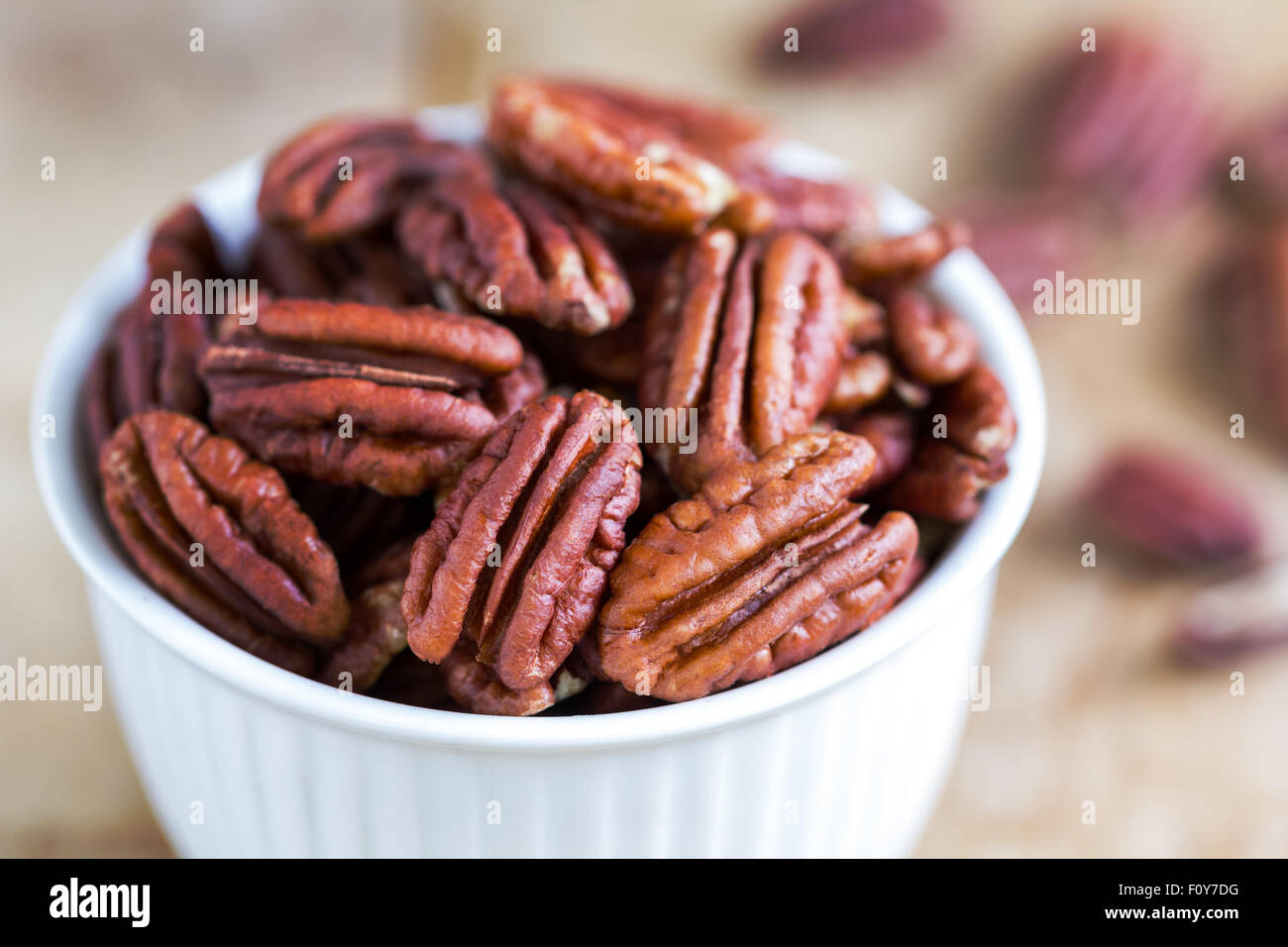 Raw Pecan in a white bowl on wooden board Stock Photo - Alamy