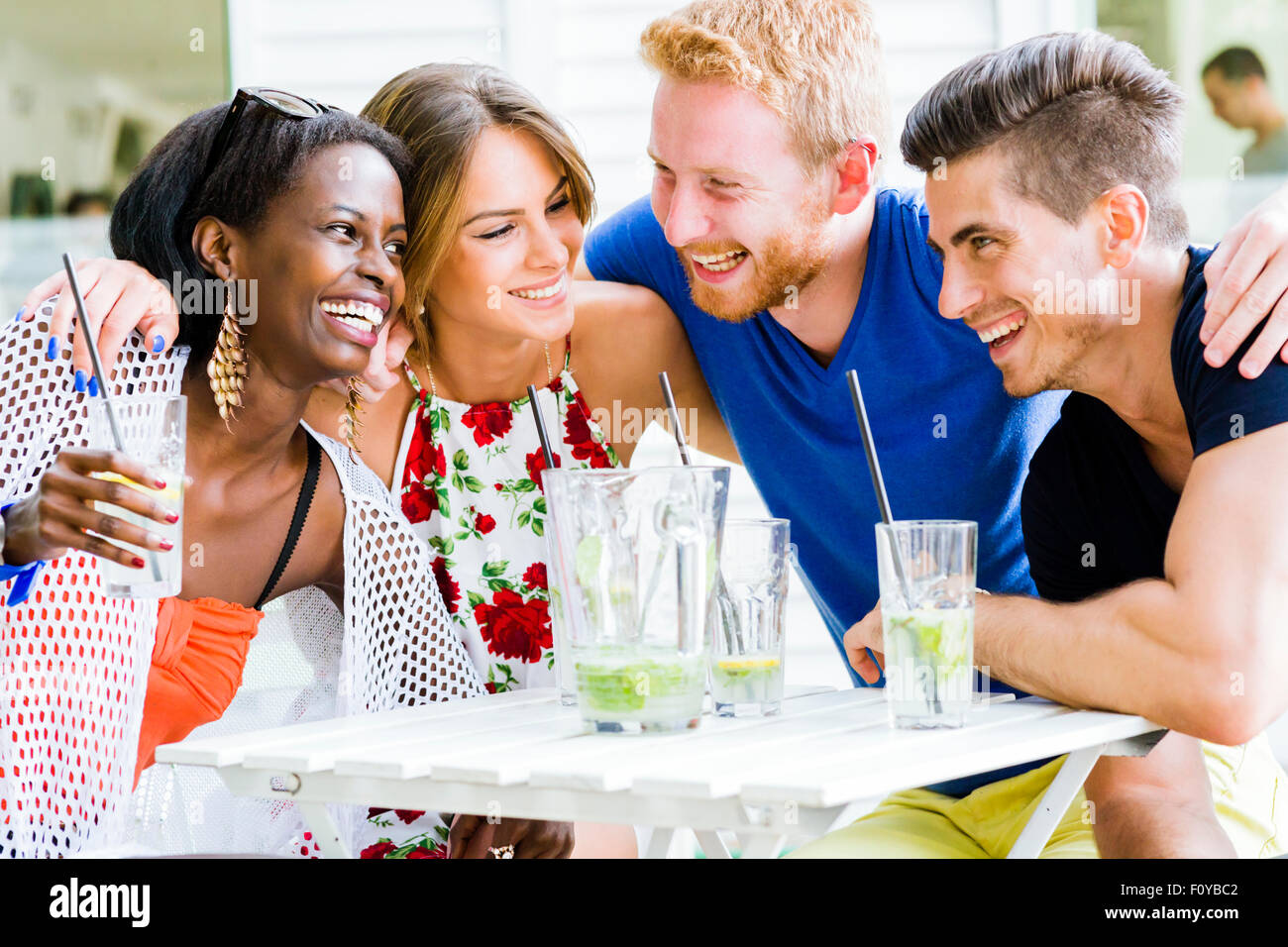 Friends laughing and hugging each other outdoors and being happy Stock ...