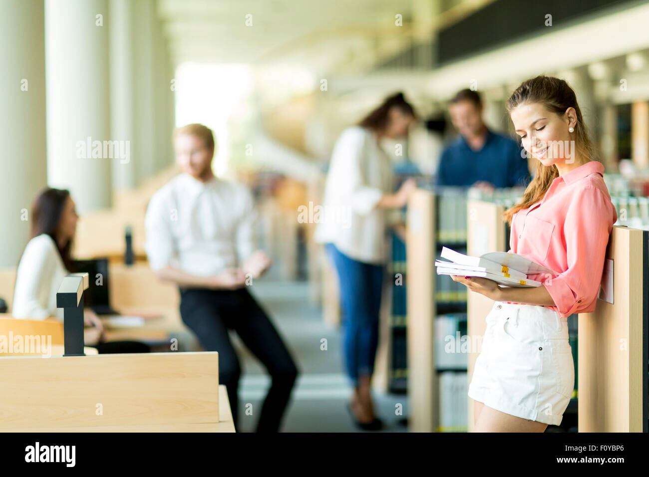 Young woman in the library Stock Photo - Alamy