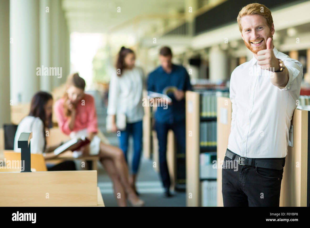 Young man in the library Stock Photo - Alamy