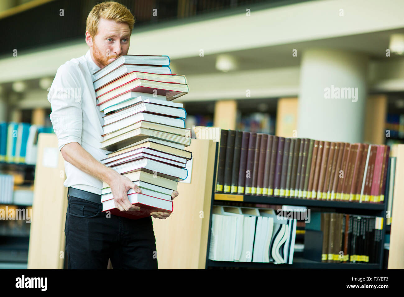 Young man in the library Stock Photo - Alamy