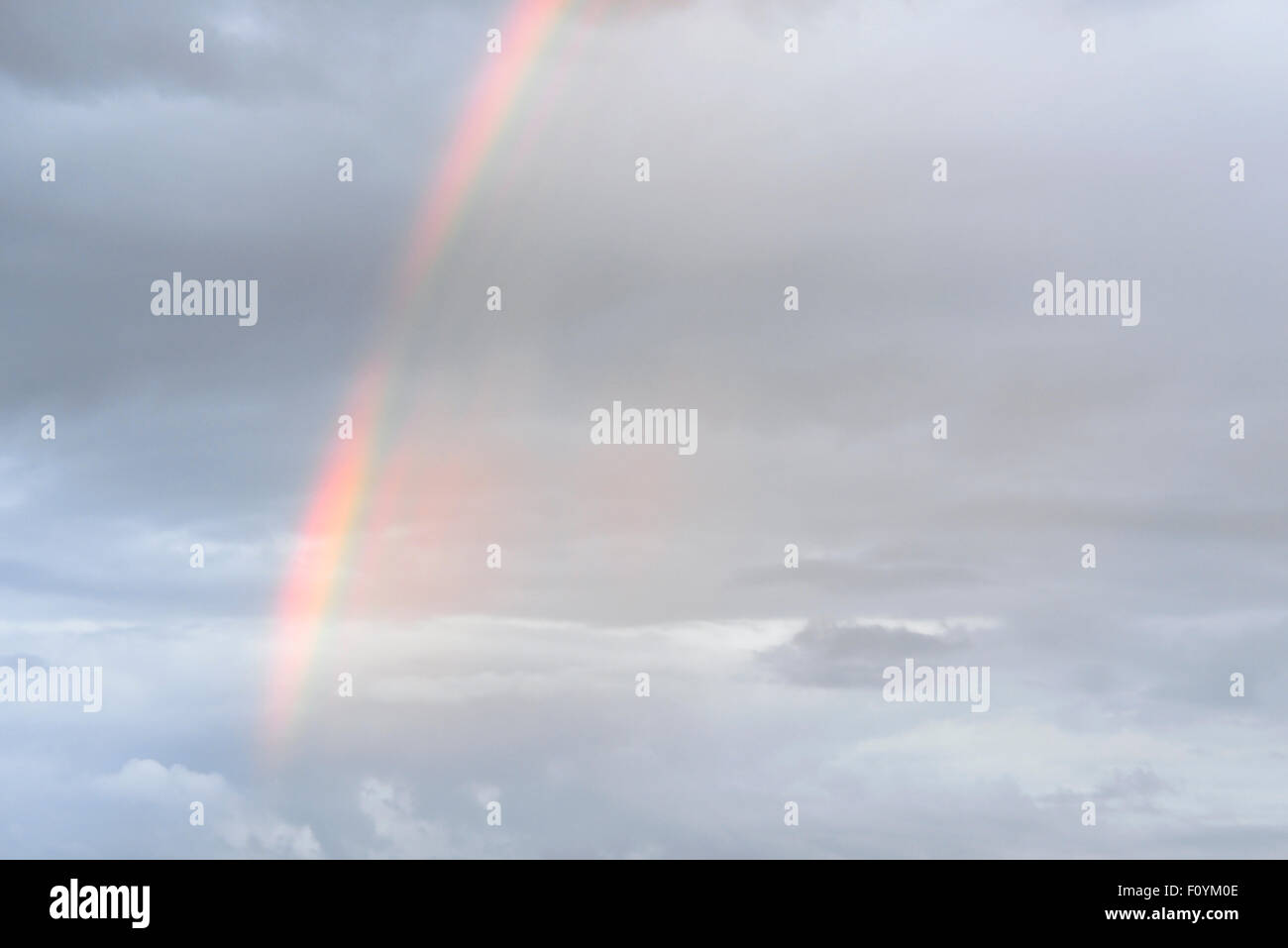 A faint rainbow showing up after a thunderstorm Stock Photo - Alamy