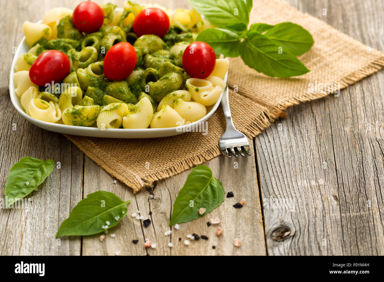 Basil pesto with shell shaped pasta and cherry tomatoes. Selective ...