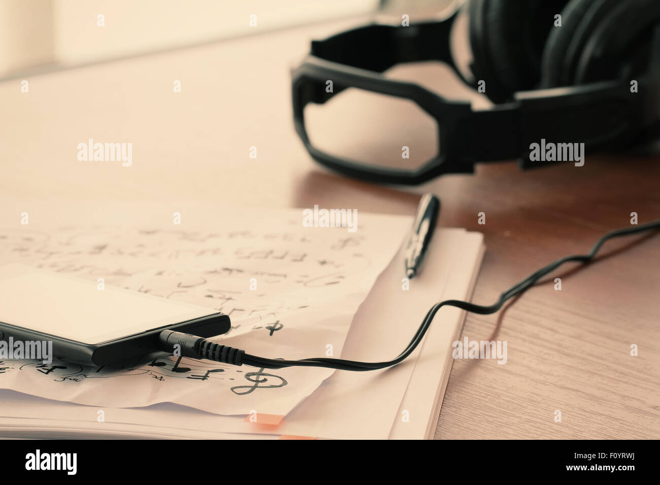 Closeup of smartphone with headphone on musical notes paper with ...