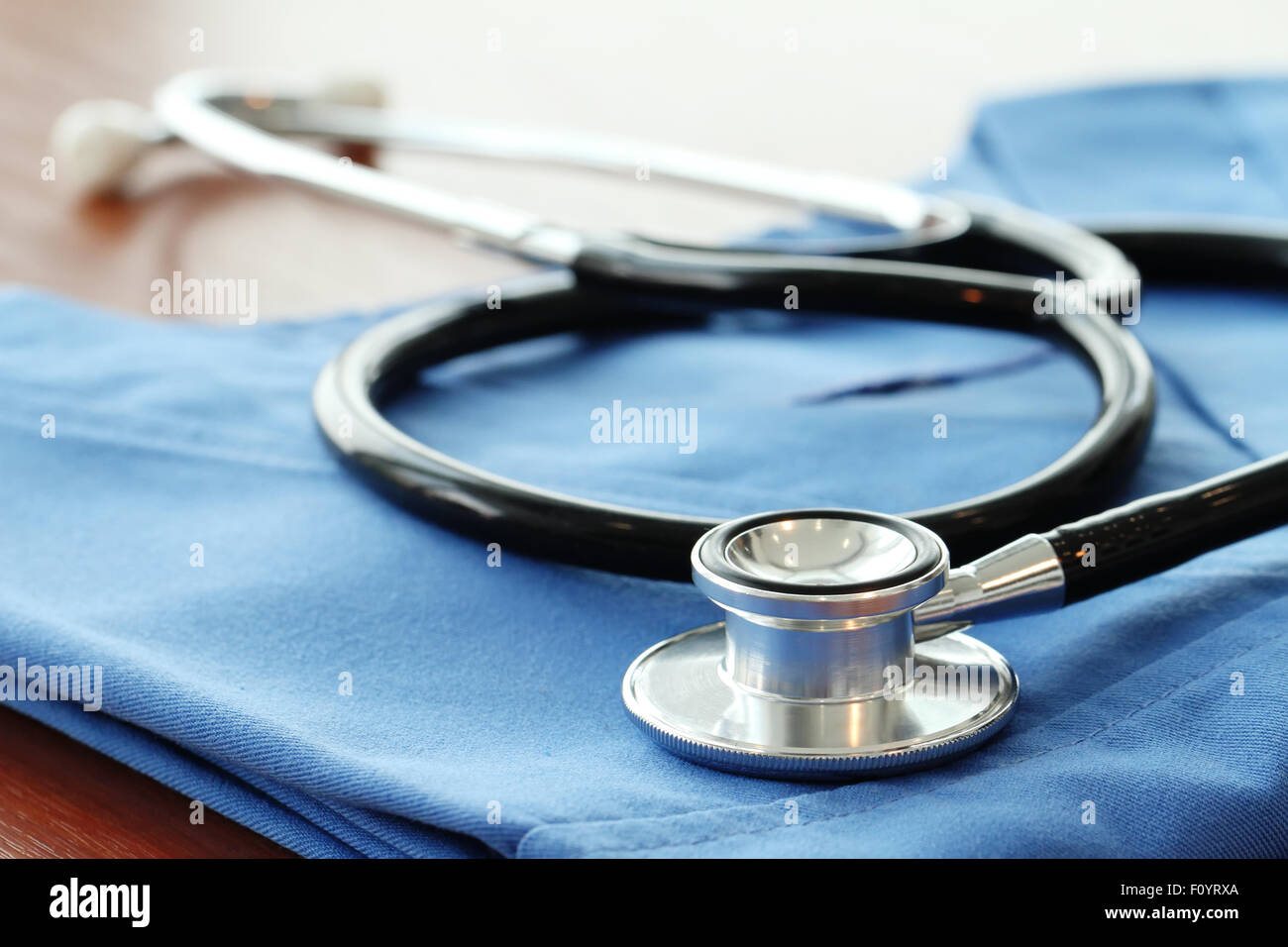 Stethoscope with blue doctor coat on wooden table and background Stock ...
