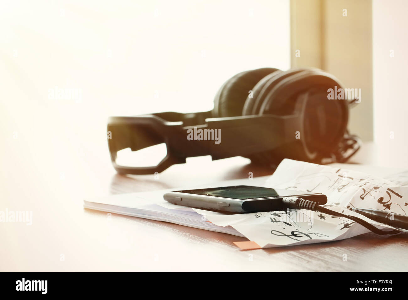Closeup of smartphone with headphone on musical notes paper with ...
