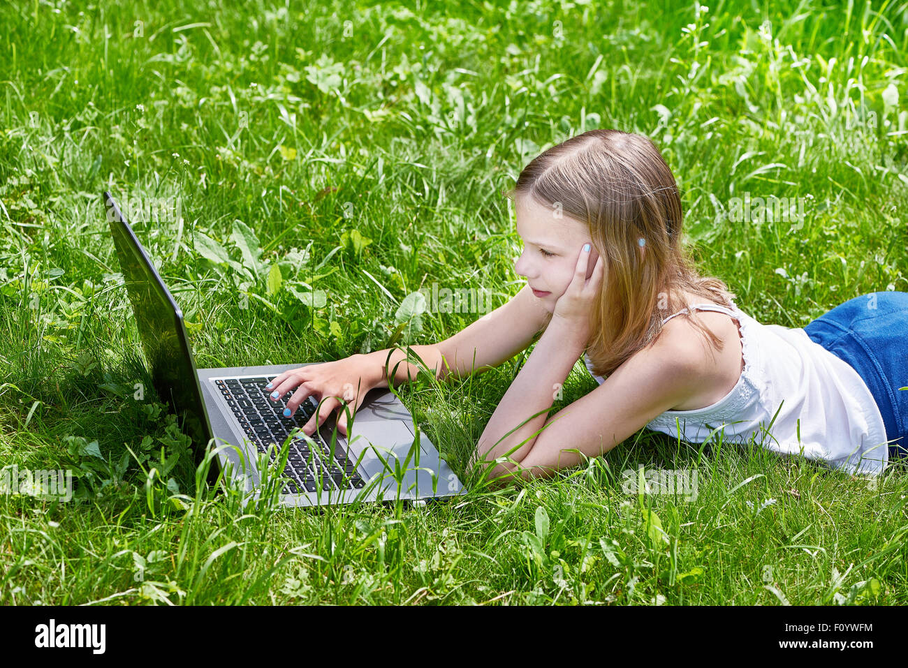 Girl using laptop on grass outdoor Stock Photo - Alamy