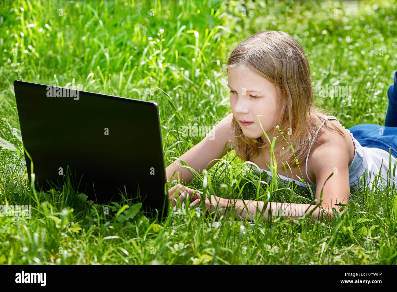 Girl using laptop on grass outdoor Stock Photo - Alamy
