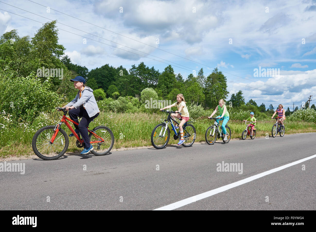 Happy kids on a bike ride on a country road Stock Photo - Alamy