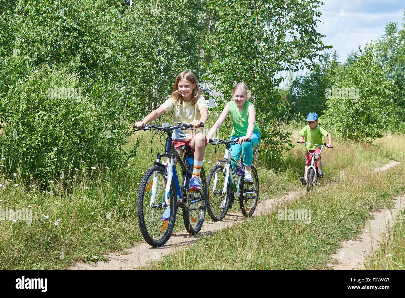 Happy kids on a bike ride on a country road Stock Photo - Alamy