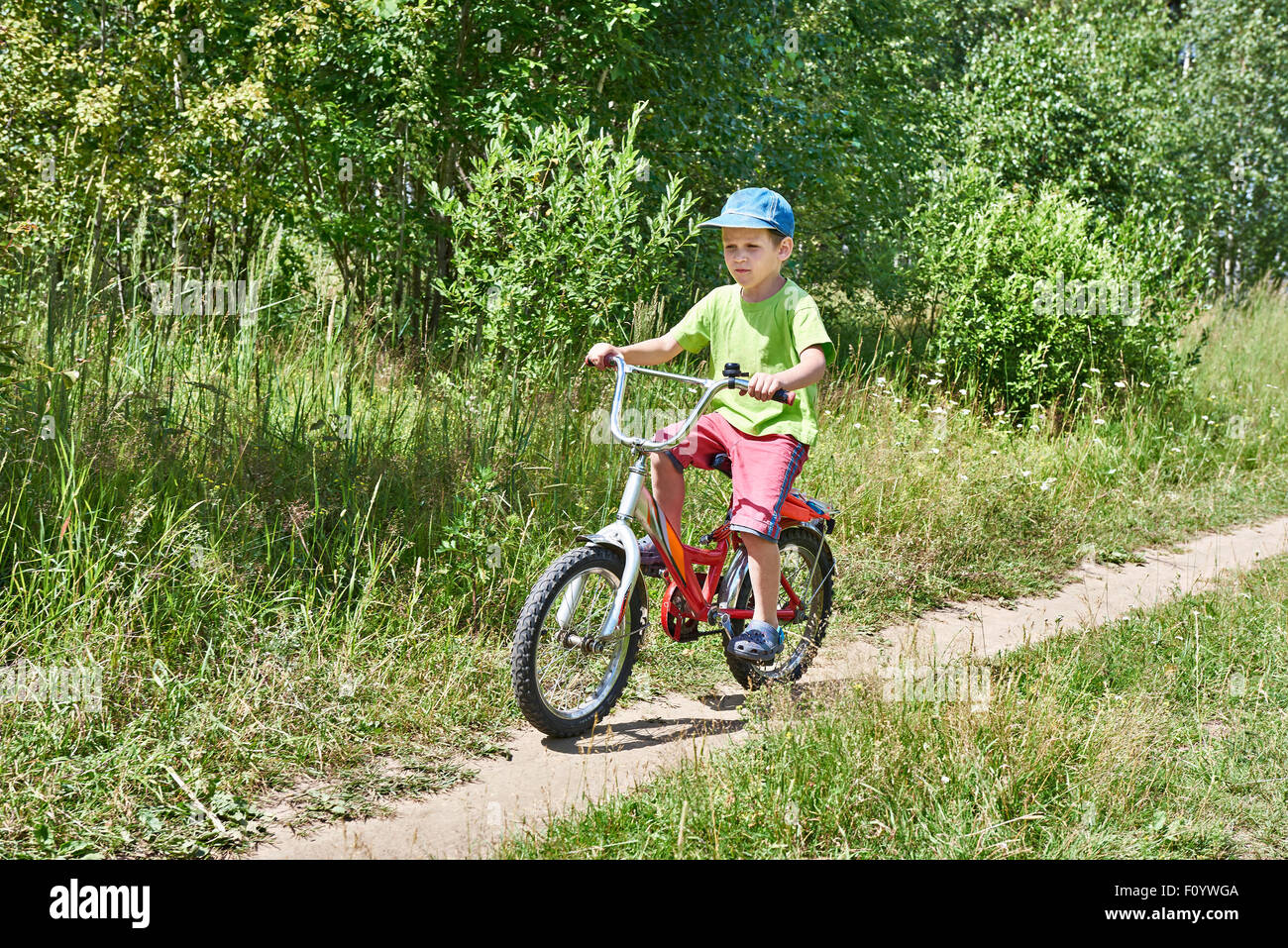 Little boy on a bike ride on a country road Stock Photo - Alamy