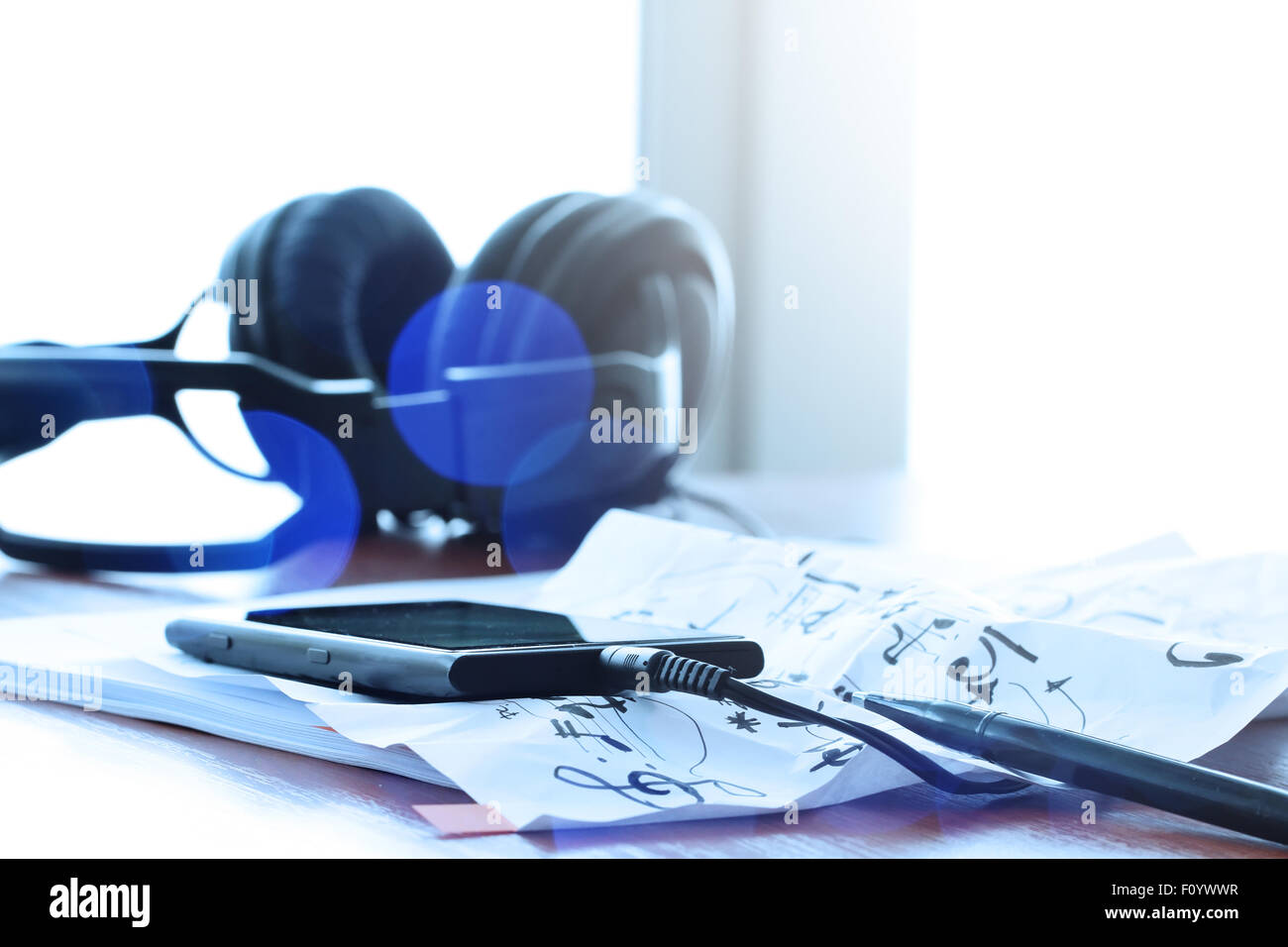 Closeup of smart phone with headphone on musical notes paper with ...