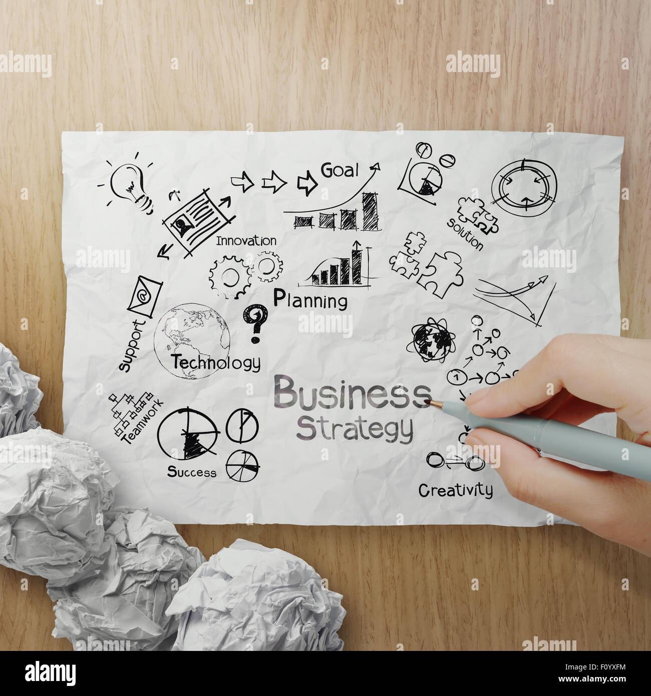hand drawing creative business strategy on crumpled paper with woden ...