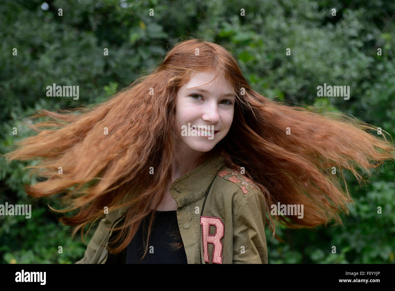 Teenage girl with long red hair, flicking her hair, Germany Stock Photo ...