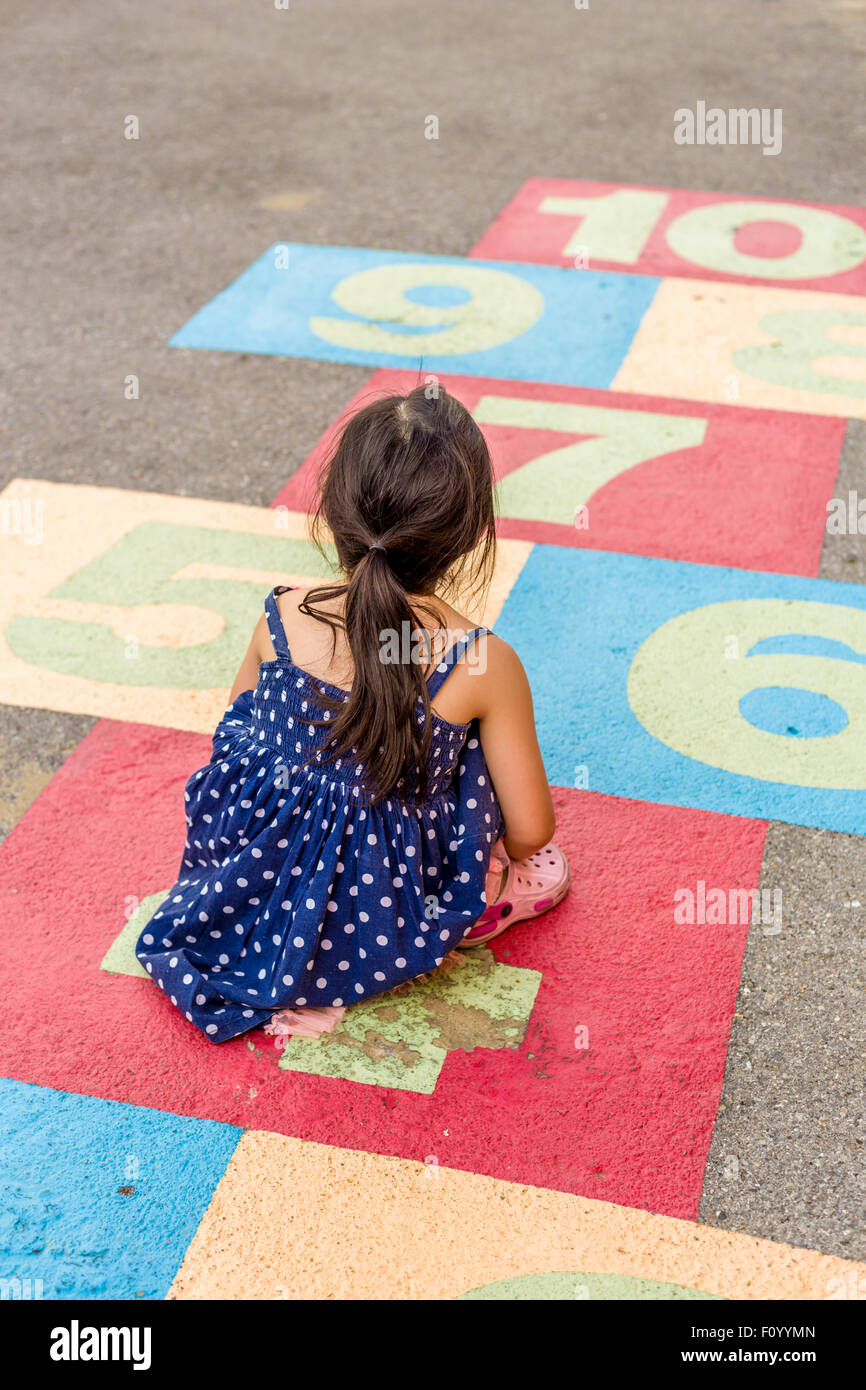 Young girl playing hopscotch on playground with happiness Stock Photo ...