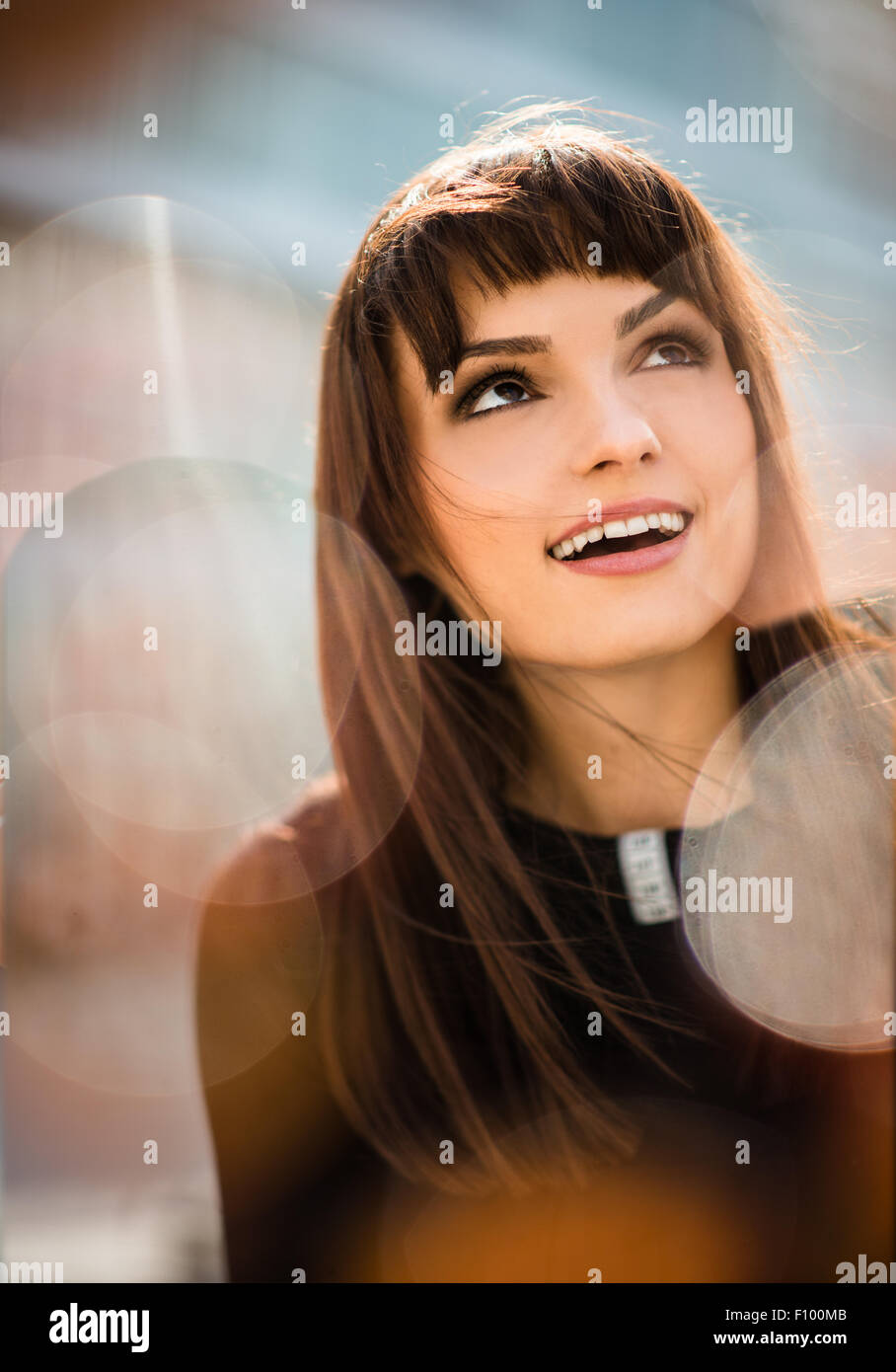 Smiling woman looking up - photo with flare reflections Stock Photo - Alamy