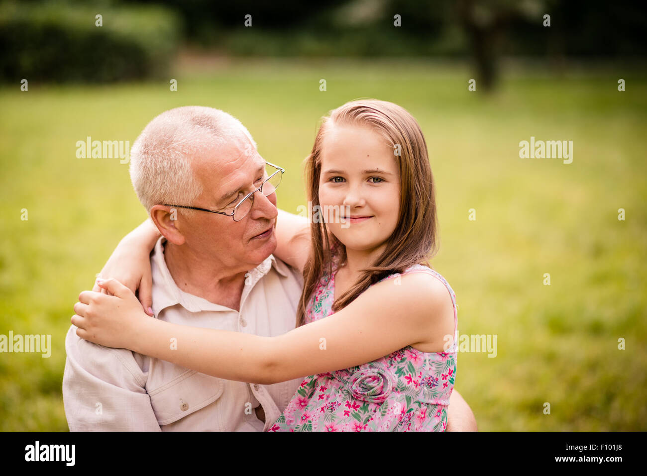 Smiling child hugging her happy grandfather - outdor in nature Stock ...