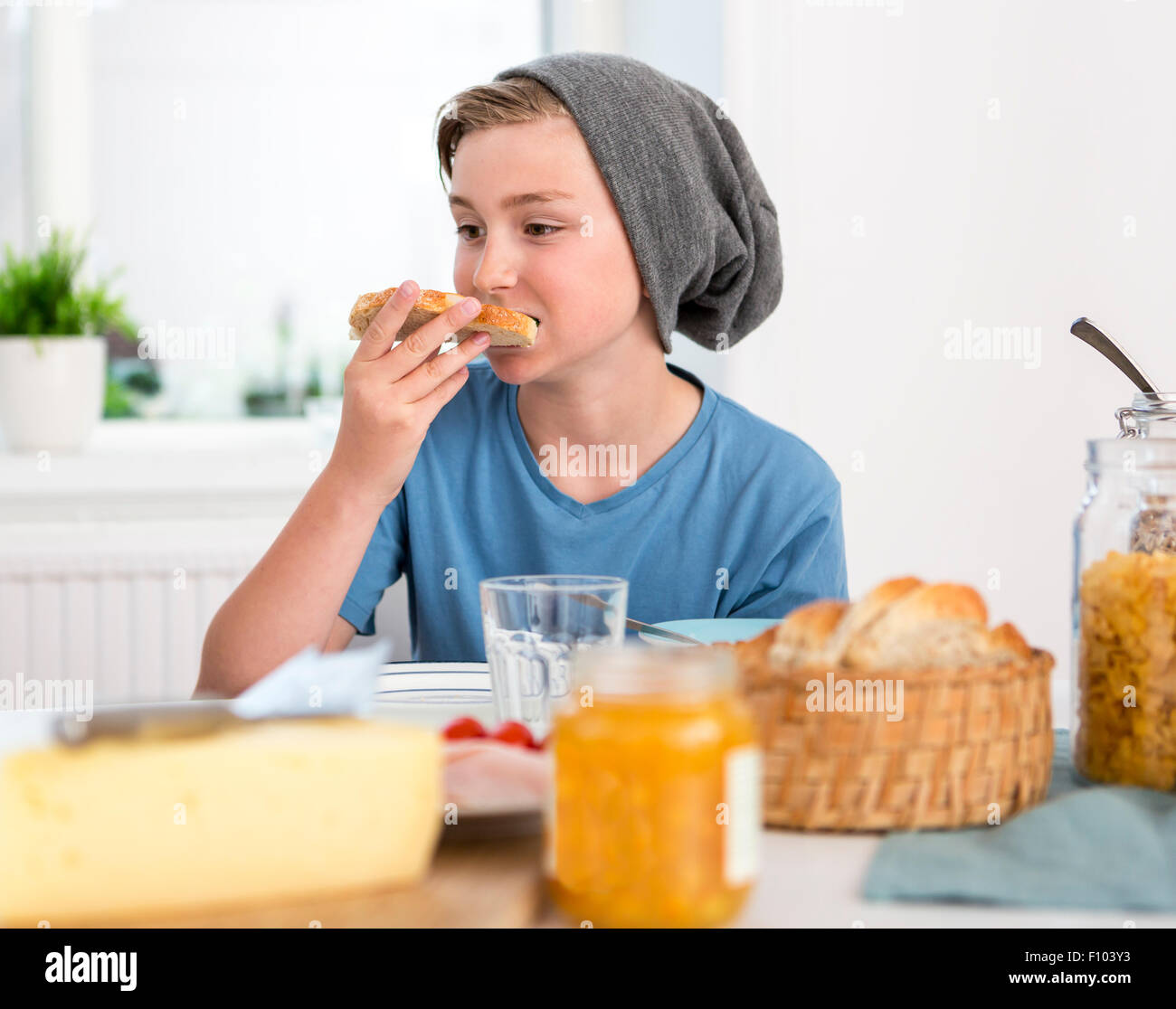 Teenage boy eating breakfast in the kitchen Stock Photo - Alamy