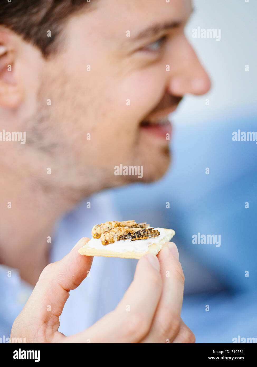 MAN EATING INSECT Stock Photo - Alamy
