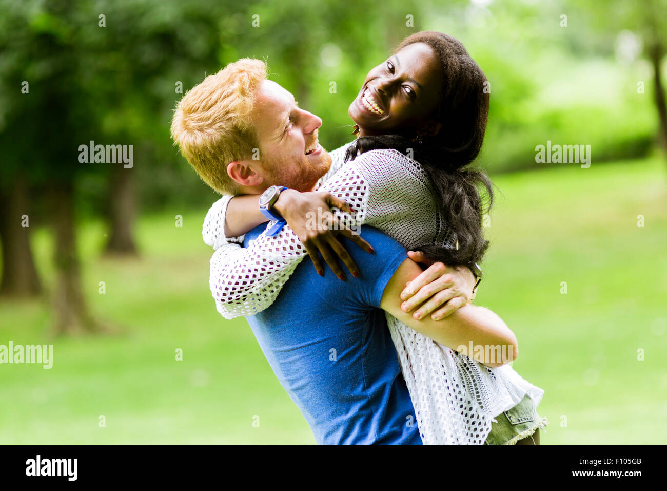 Portrait of a happy couple dancing and hugging in a park outdoors Stock ...