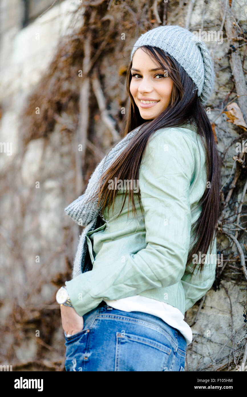 Portrait of a young beautiful woman in autumn ambient as leaning ...