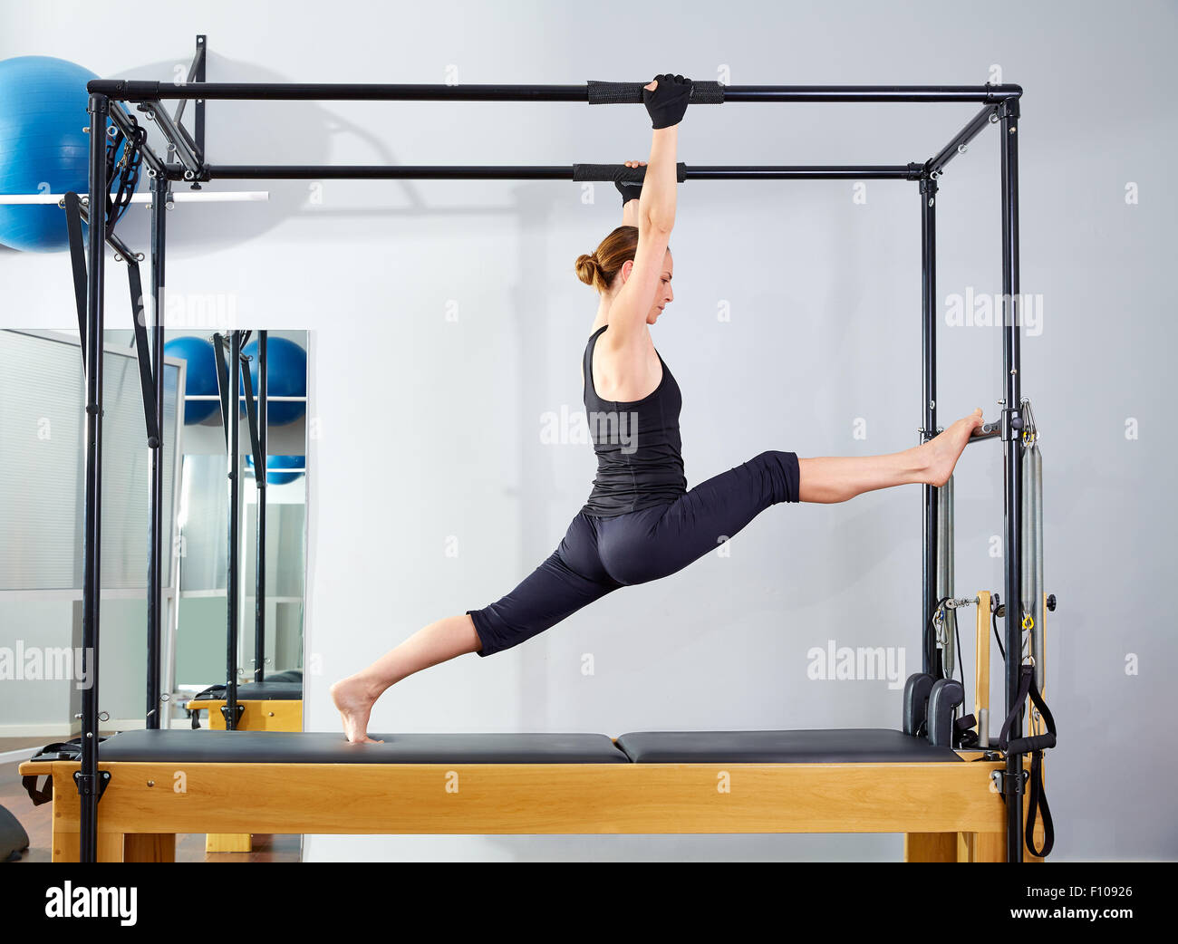Pilates woman in cadillac legs split reformer exercise at gym Stock ...