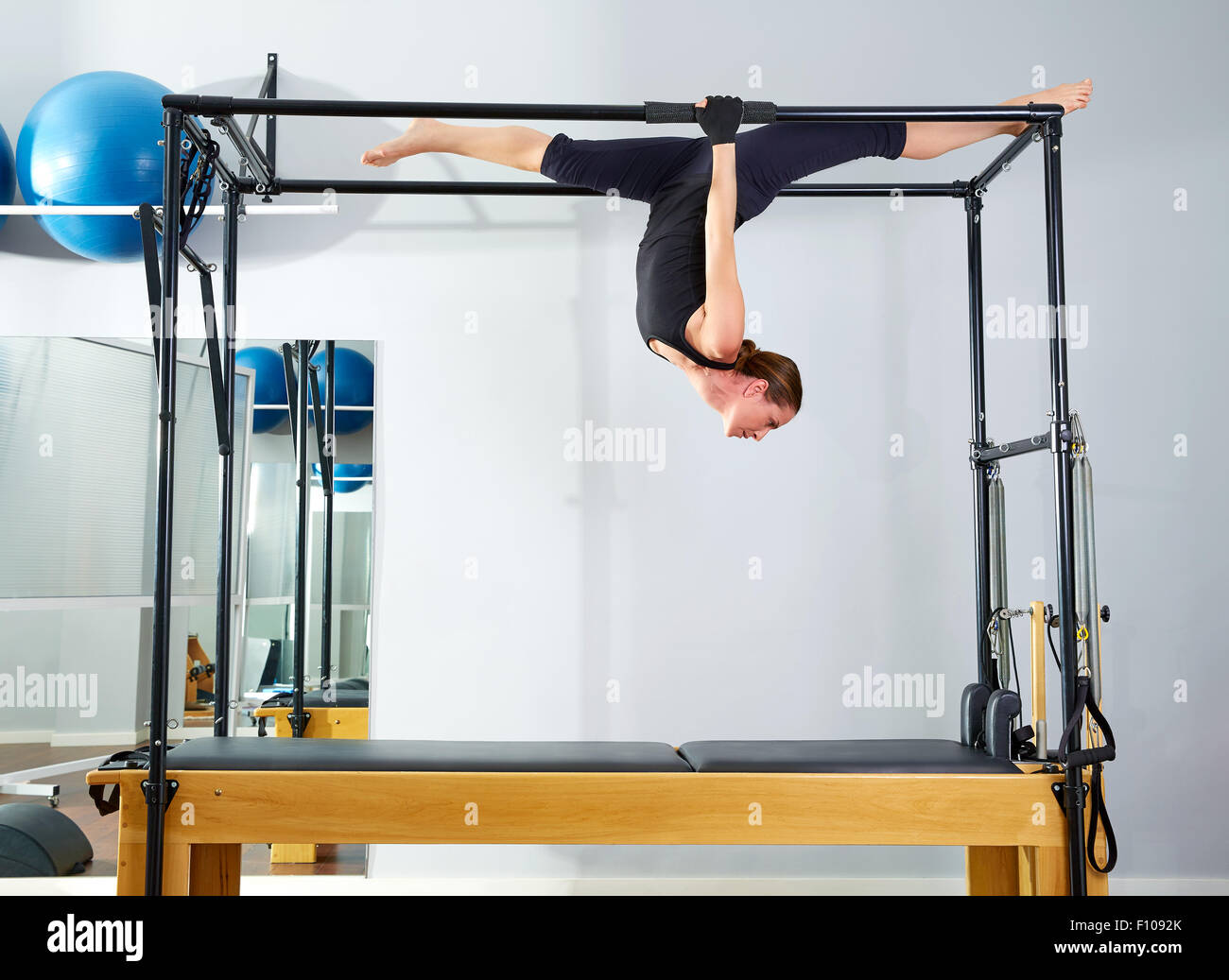Pilates woman in cadillac walk over reformer upside down exercise at ...