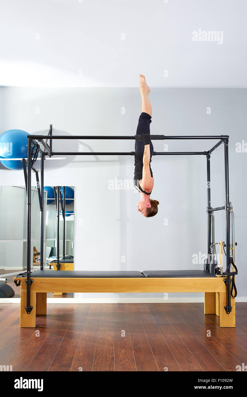 Pilates woman in cadillac acrobatic upside down balance reformer ...