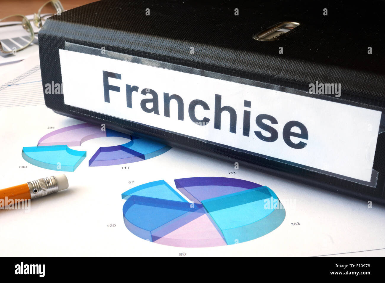 Graphs and file folder with label franchise. Business concept Stock ...