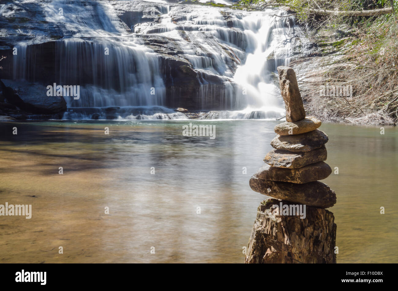 A stack of rocks at the base of a waterfall in late spring Stock Photo ...